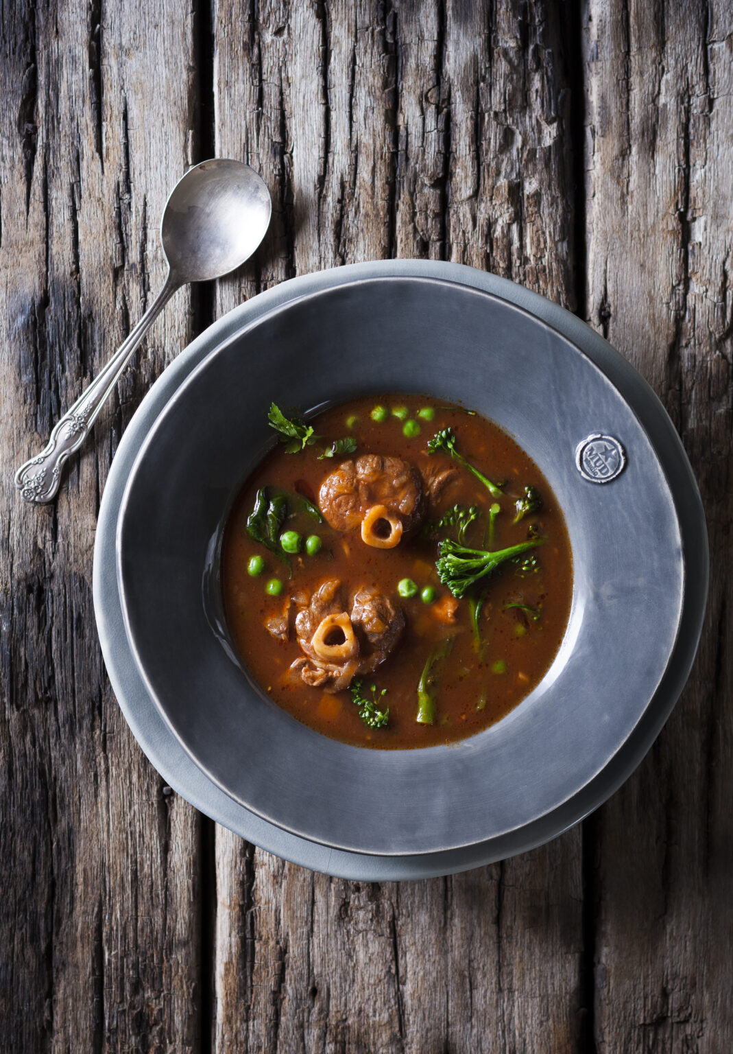 Spicy tomato and lamb knuckle soup with baby spinach, broccoli and peas ...